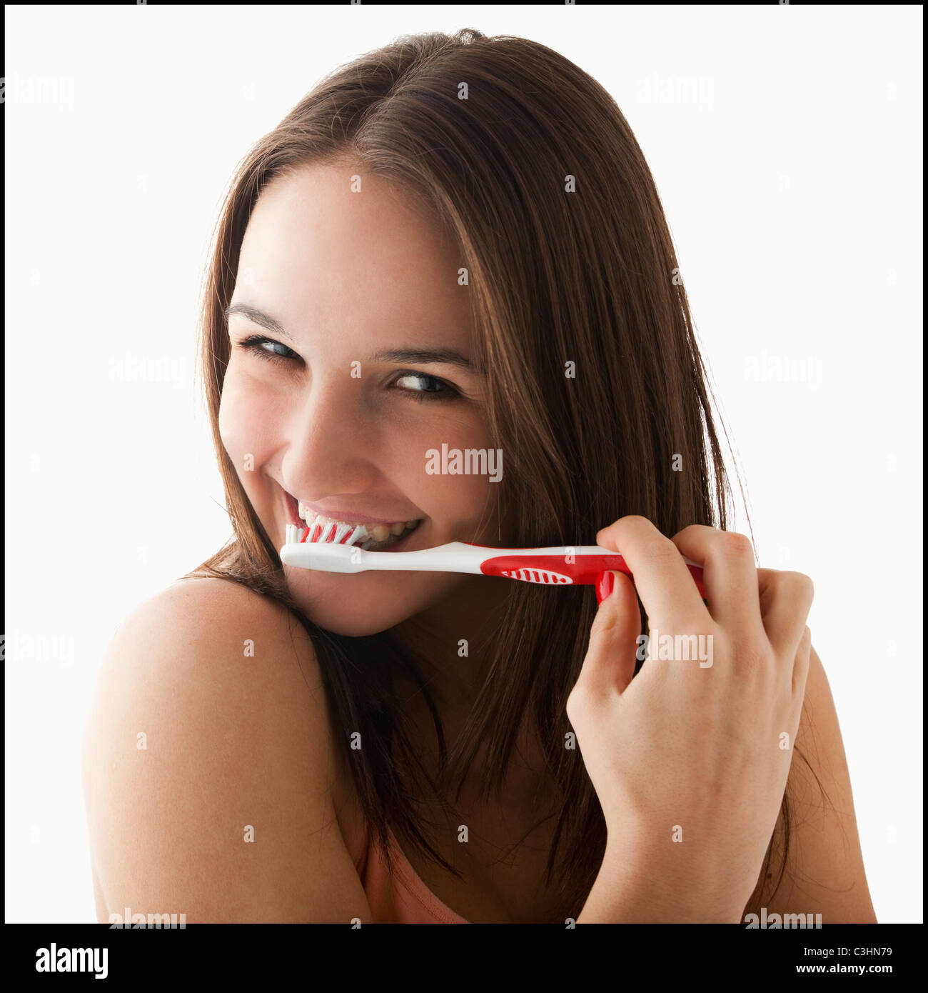 Studio portrait of young woman brushing teeth Stock Photo - Alamy
