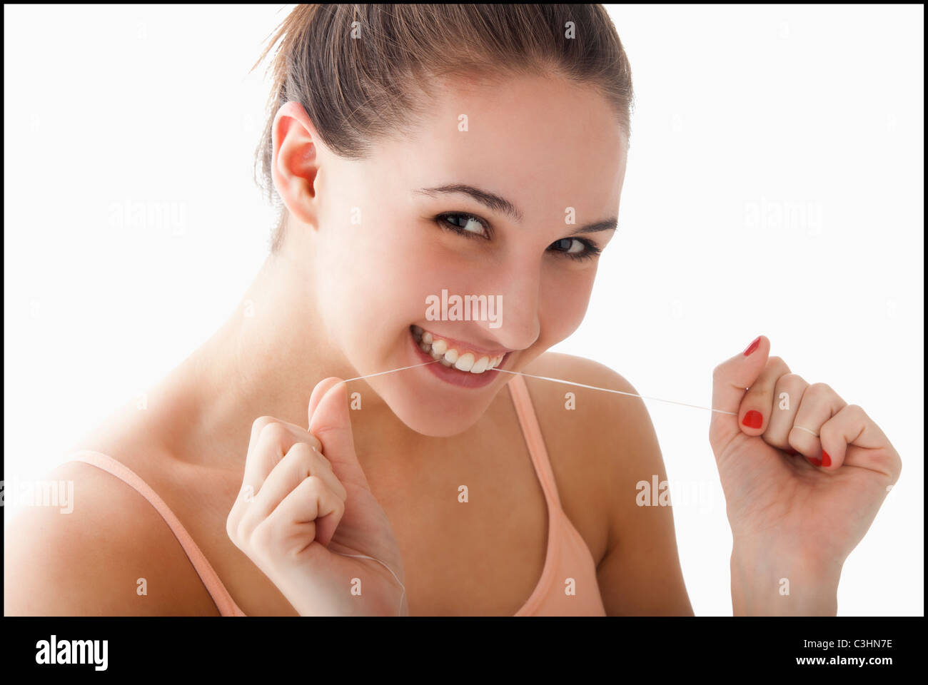 Studio portrait of young woman flossing teeth Stock Photo - Alamy