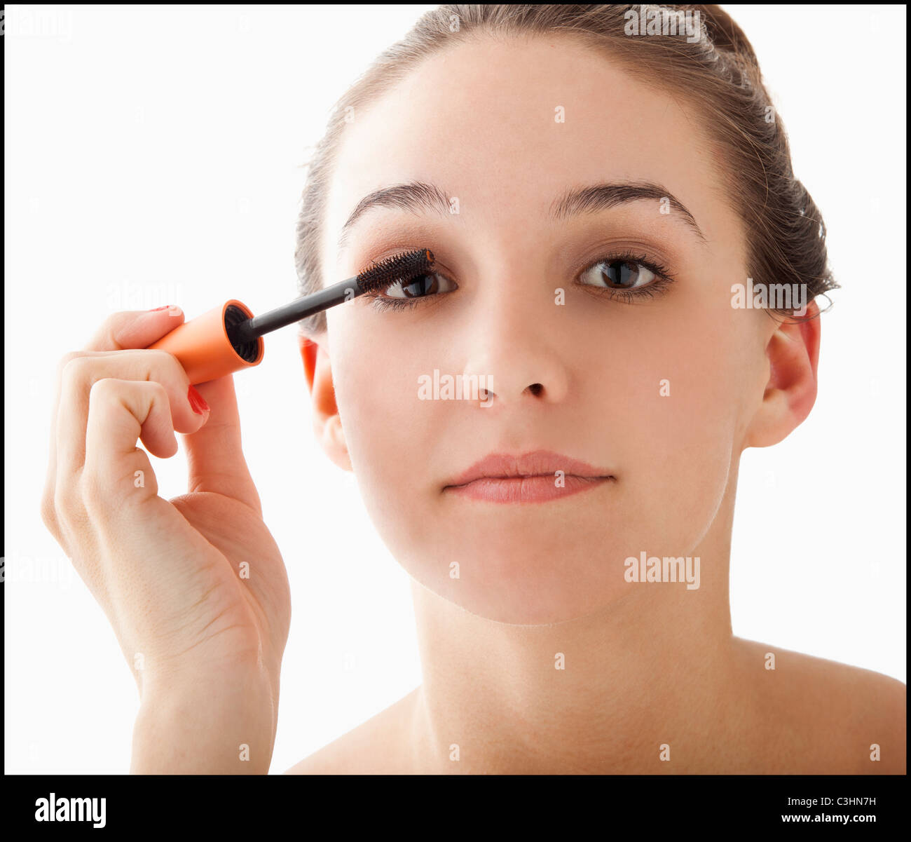 Studio portrait of young woman applying mascara Stock Photo - Alamy