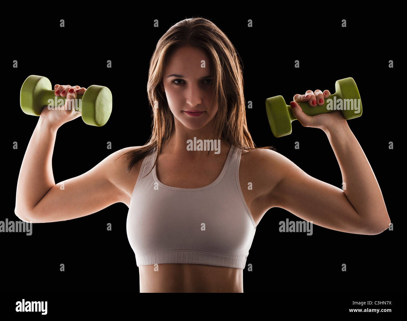 Studio portrait of young woman using hand weights Stock Photo - Alamy