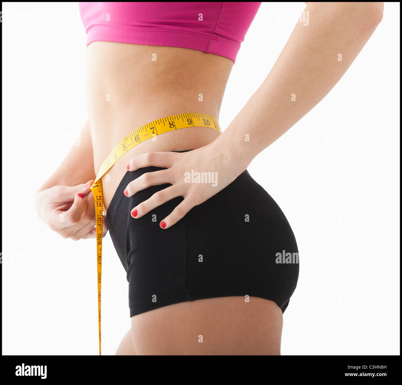 Young woman measuring waist Stock Photo - Alamy Young woman measuring waist Stock Photo - Alamy