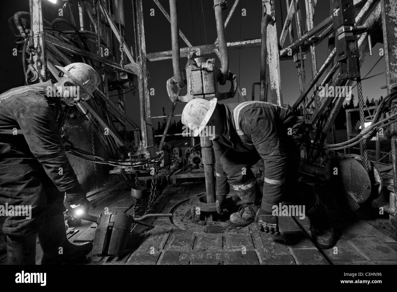 Oil workers using oil drill Stock Photo - Alamy