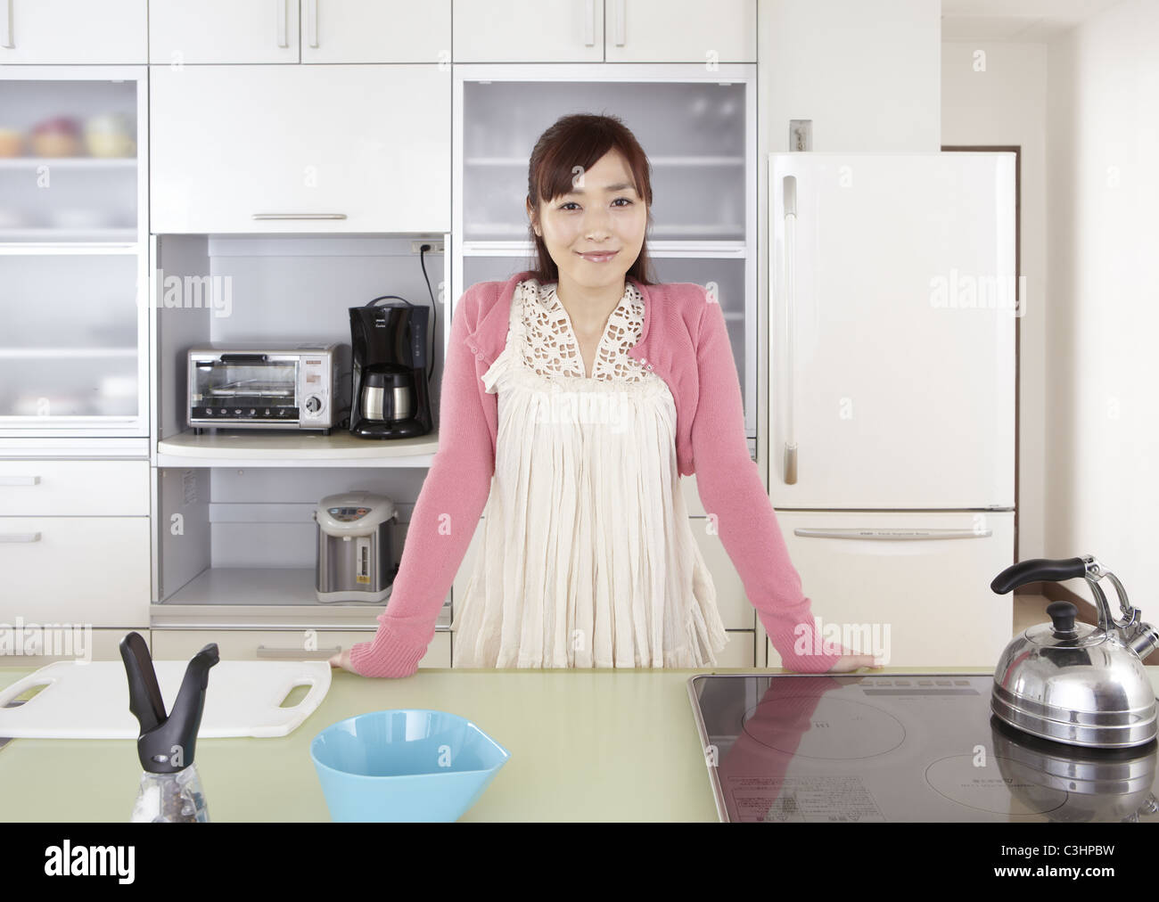 Woman standing in kitchen Stock Photo - Alamy