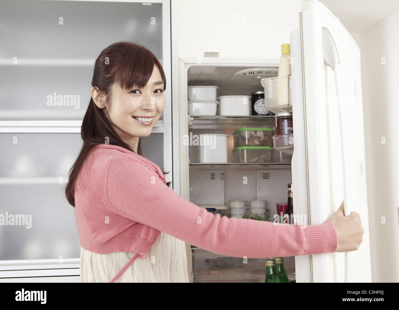 Woman opening refrigerator Stock Photo - Alamy