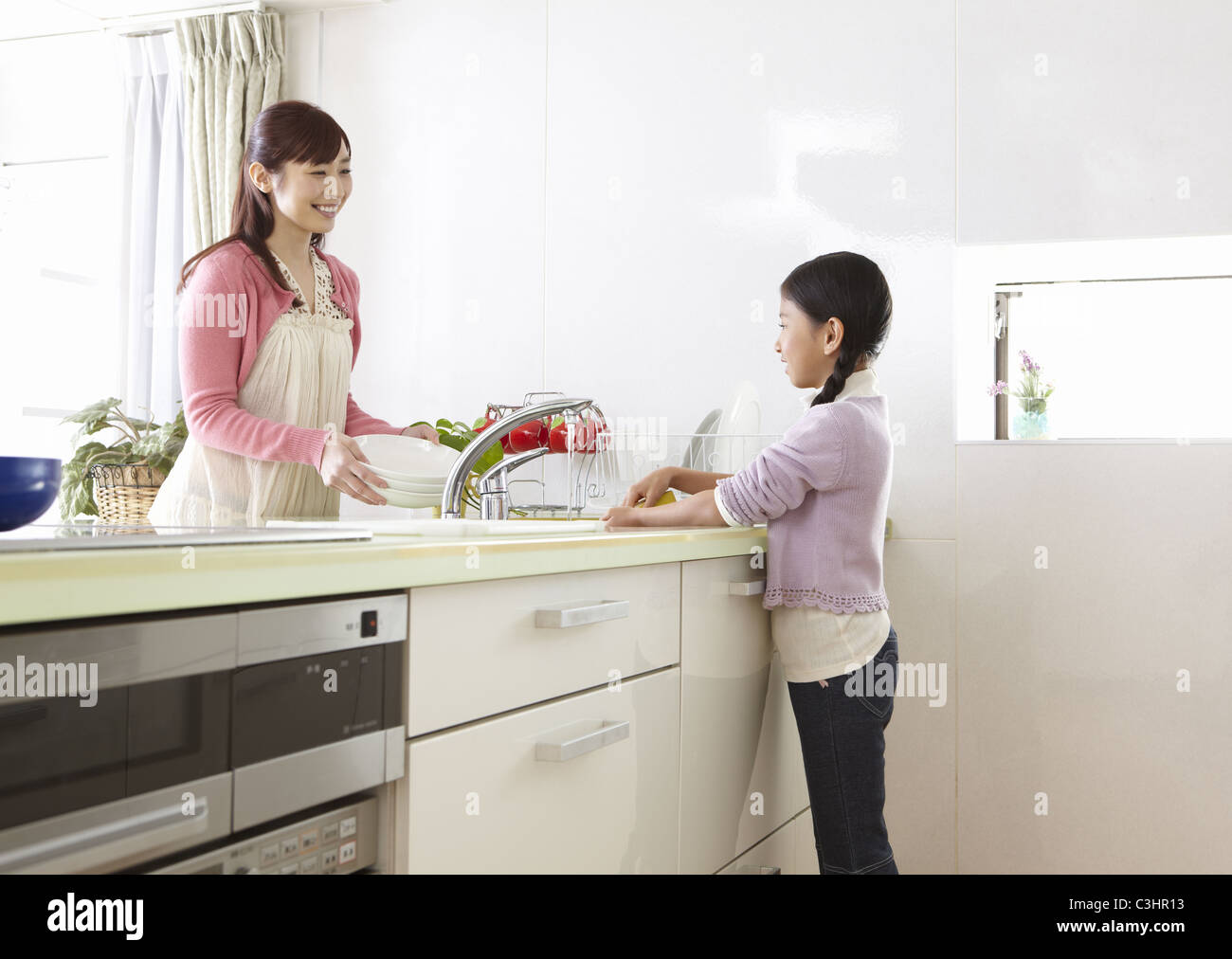 Mother and daughter washing dishes Stock Photo - Alamy
