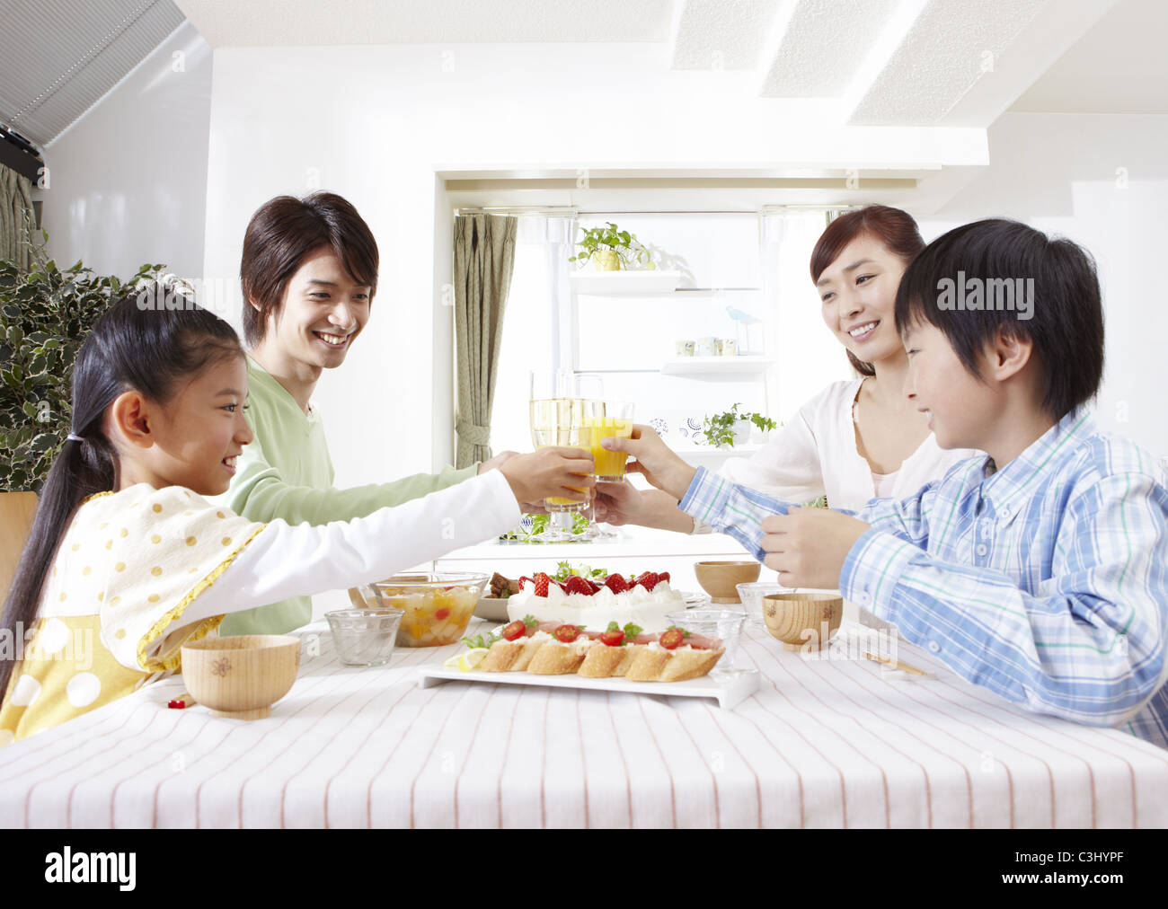Parents and kids having a toast Stock Photo - Alamy