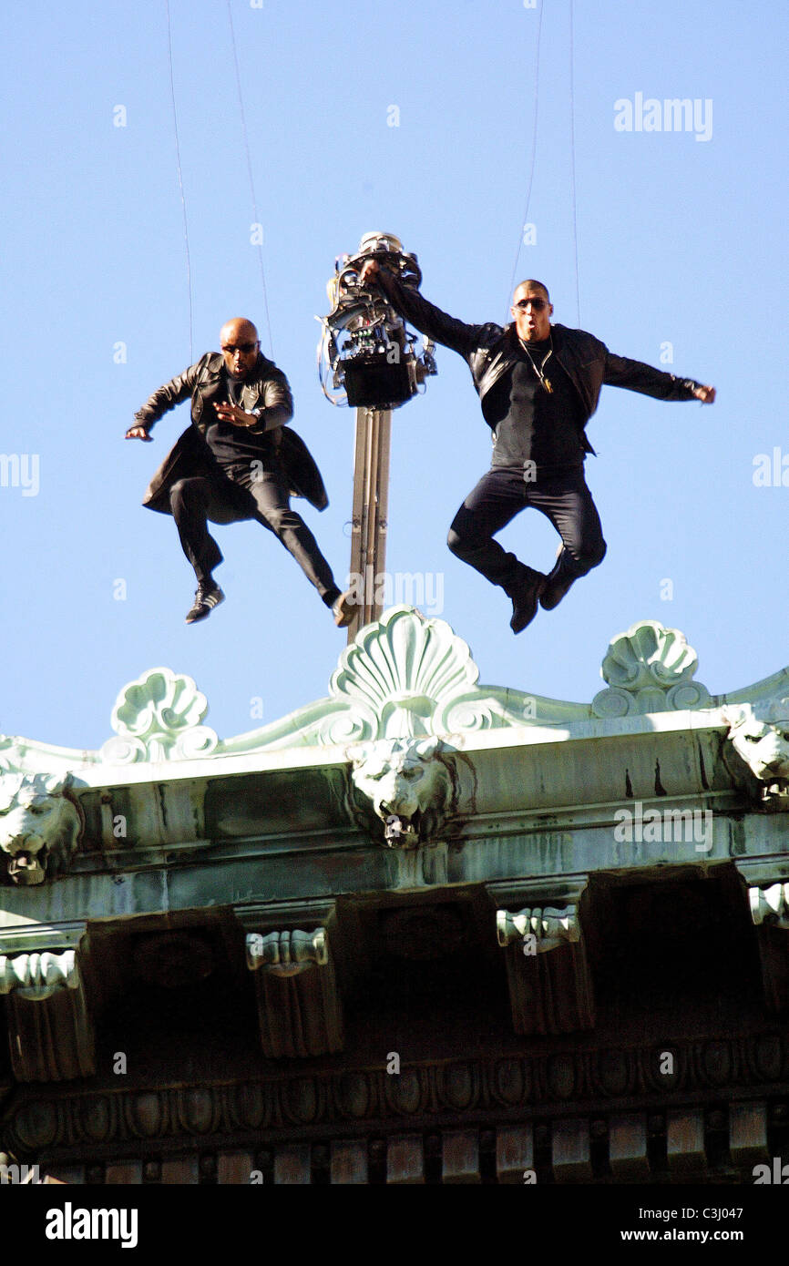 Stuntmen suspended on wires, jump off a building as they film scenes ...