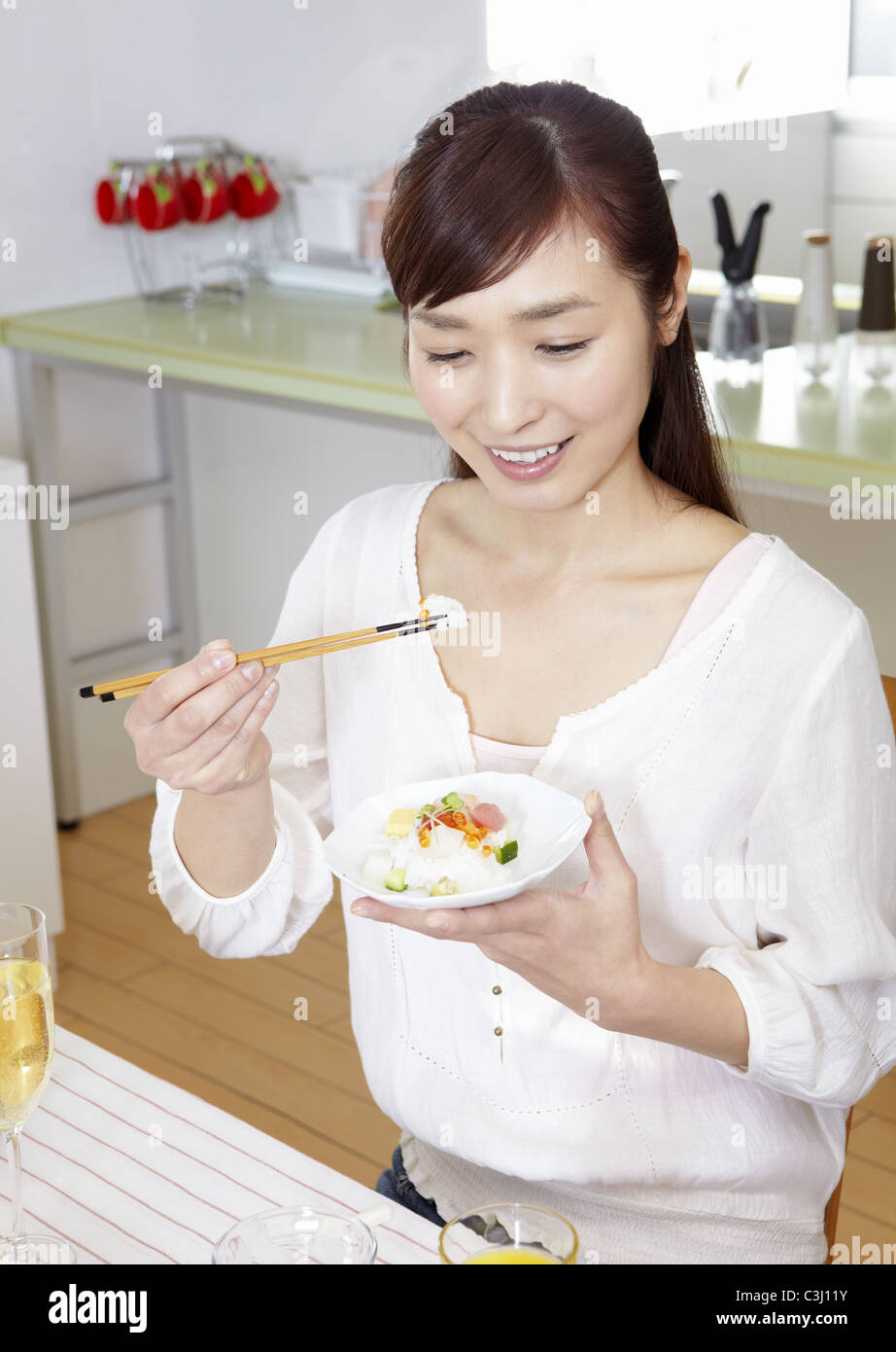 Young woman eating chirashi sushi Stock Photo - Alamy