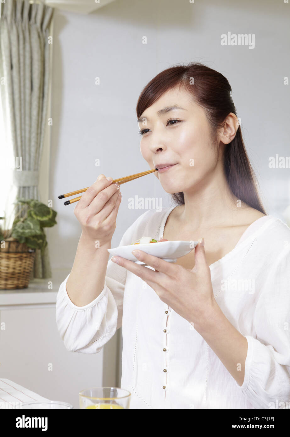Young woman eating chirashi sushi Stock Photo - Alamy