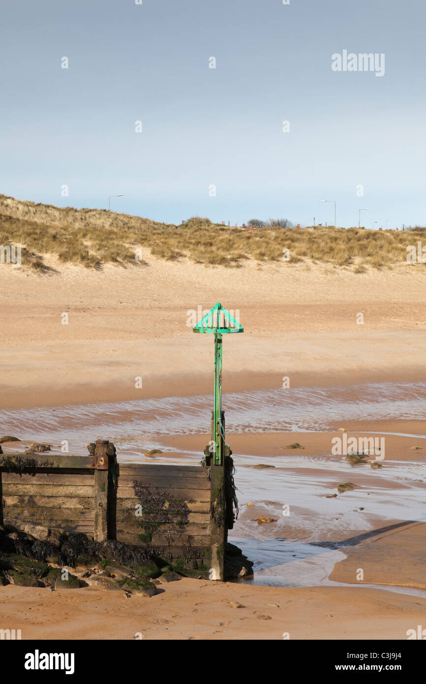 Starboard marker on a breakwater at Seaton Sluice, with the sand and ...