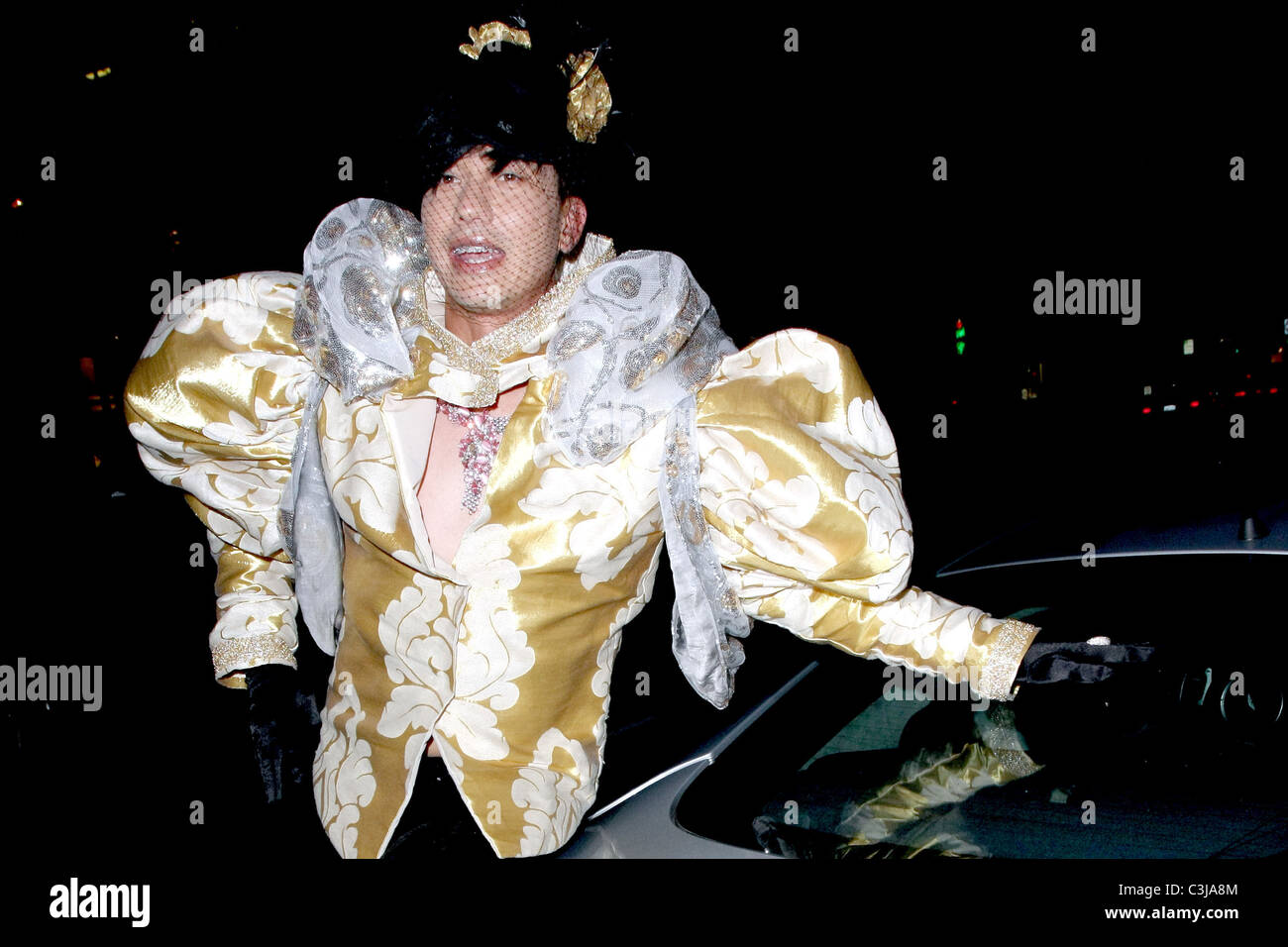 Bobby Trendy poses for photographers in an ornate gold jacket while on ...