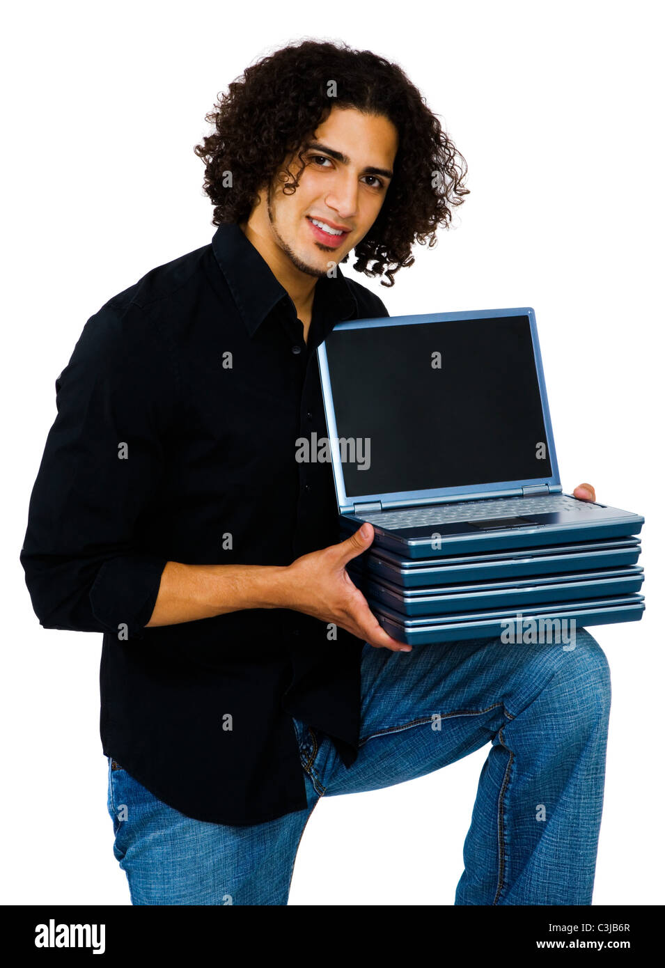 Smiling man holding a stack of laptops and posing isolated over white ...
