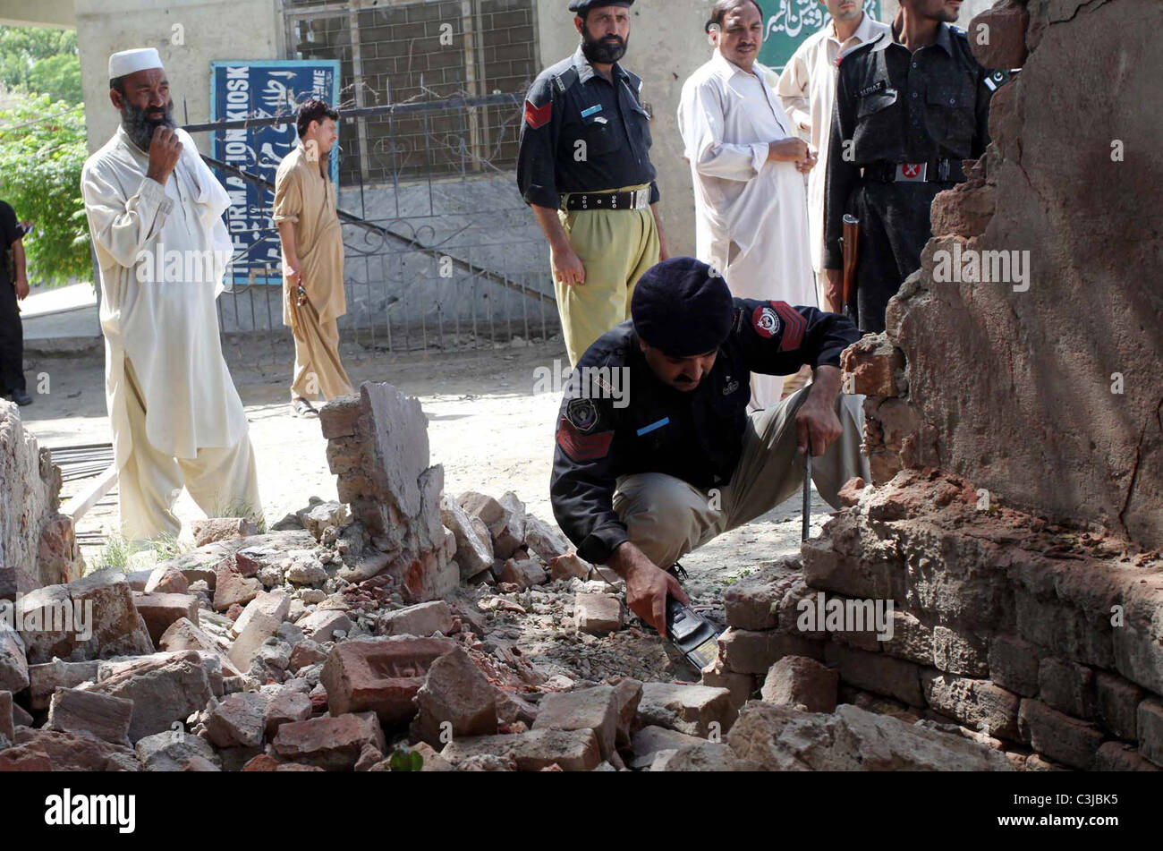 A police official inspects the site of explosion after bomb explosion ...