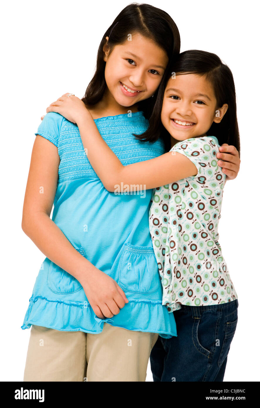 Portrait of two girls hugging each other and smiling isolated over ...