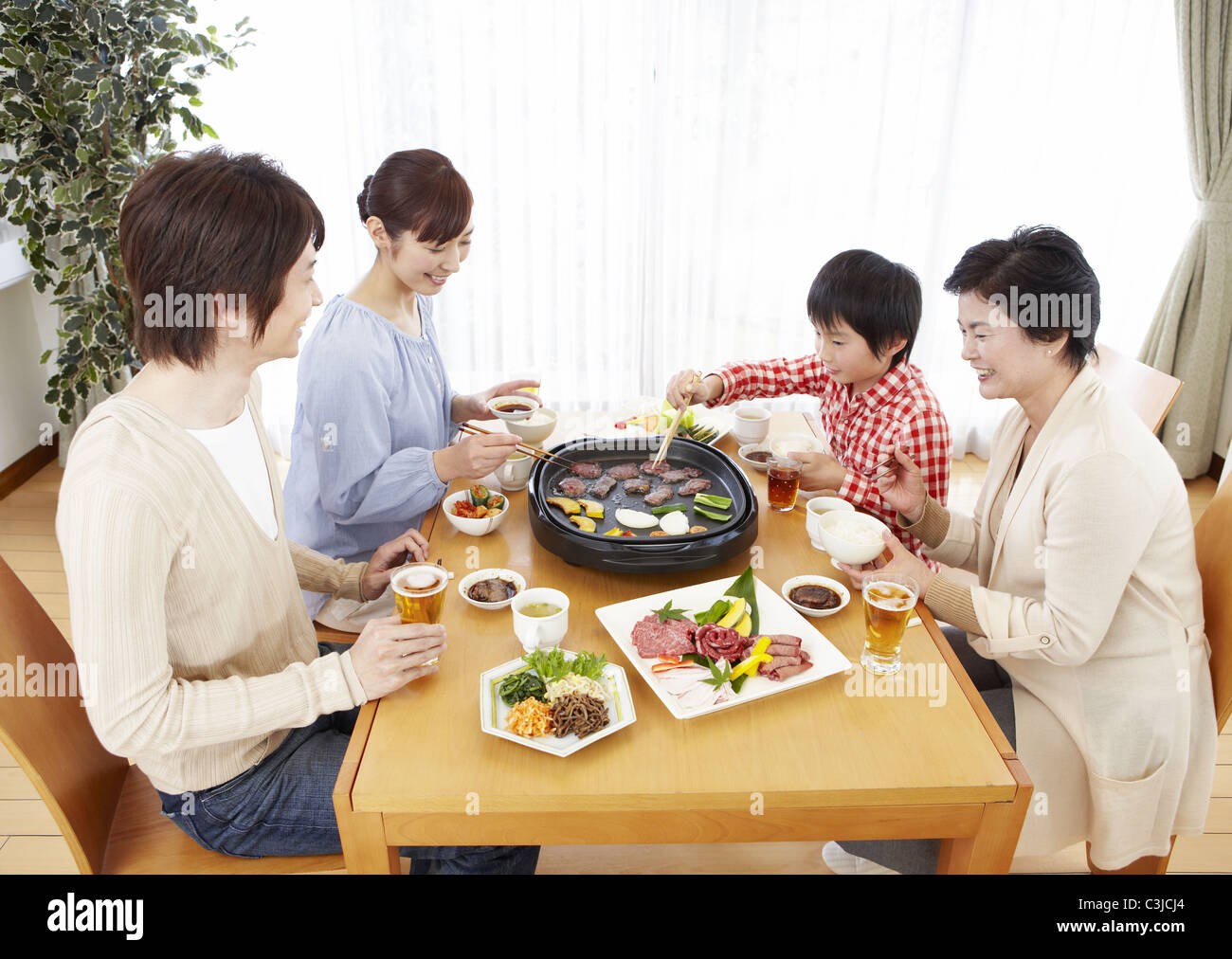 Three-generation family eating Japanese barbeque Stock Photo - Alamy
