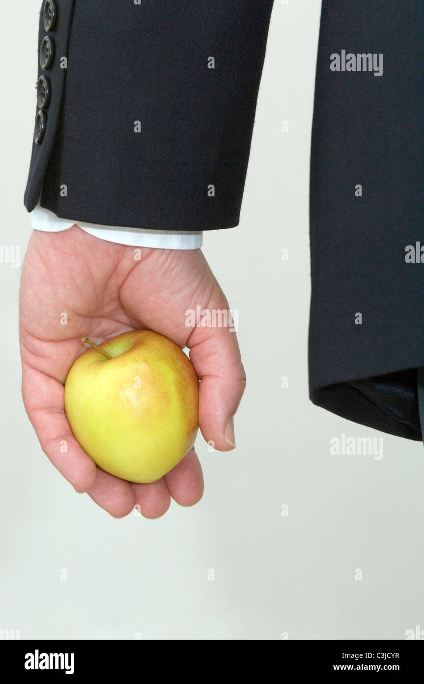 Business man with apple Mans hand holding an apple plain background ...