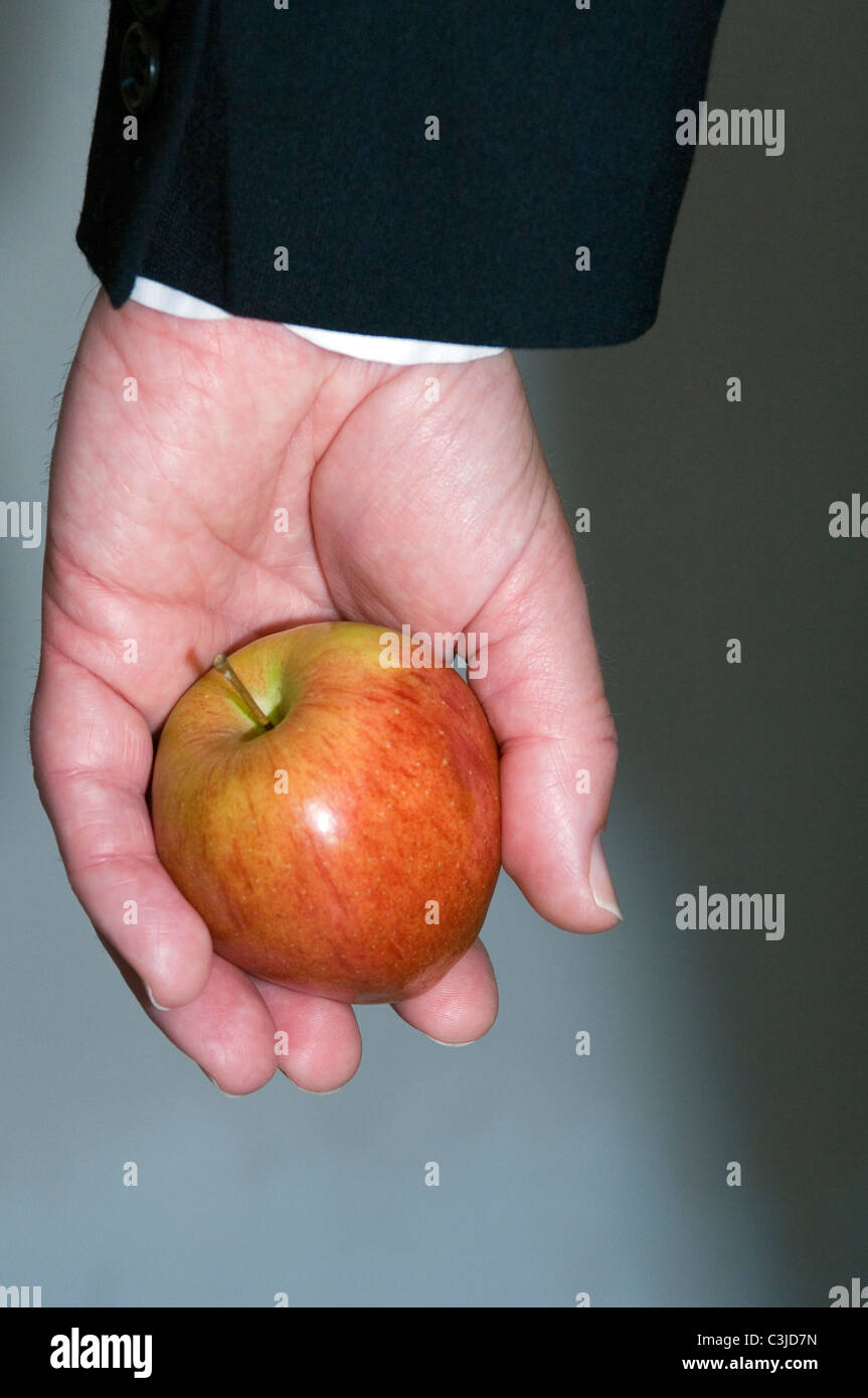 Business man with apple Mans hand holding an apple plain background ...
