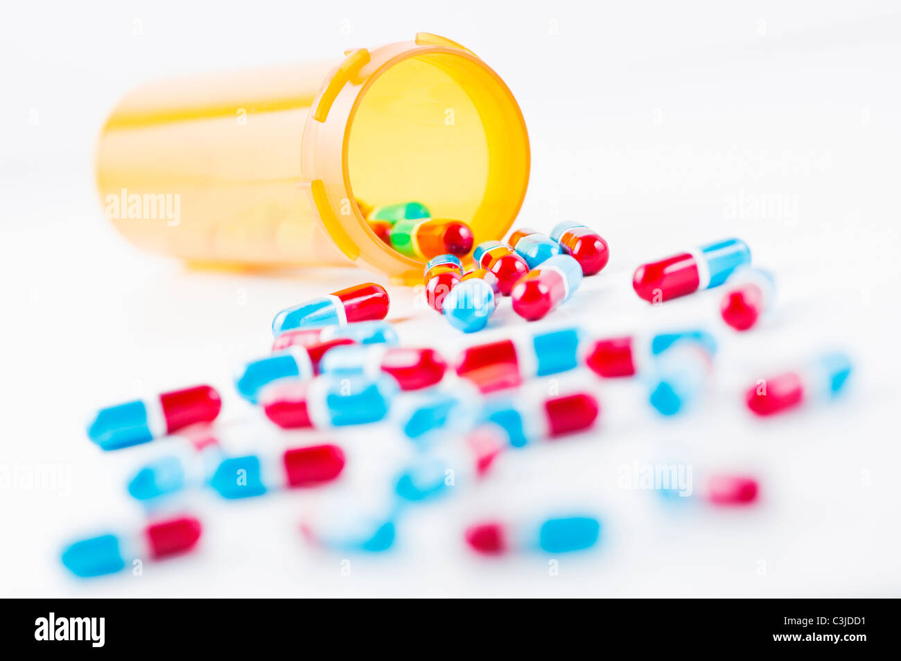Studio shot of capsules spilling from bottle Stock Photo - Alamy