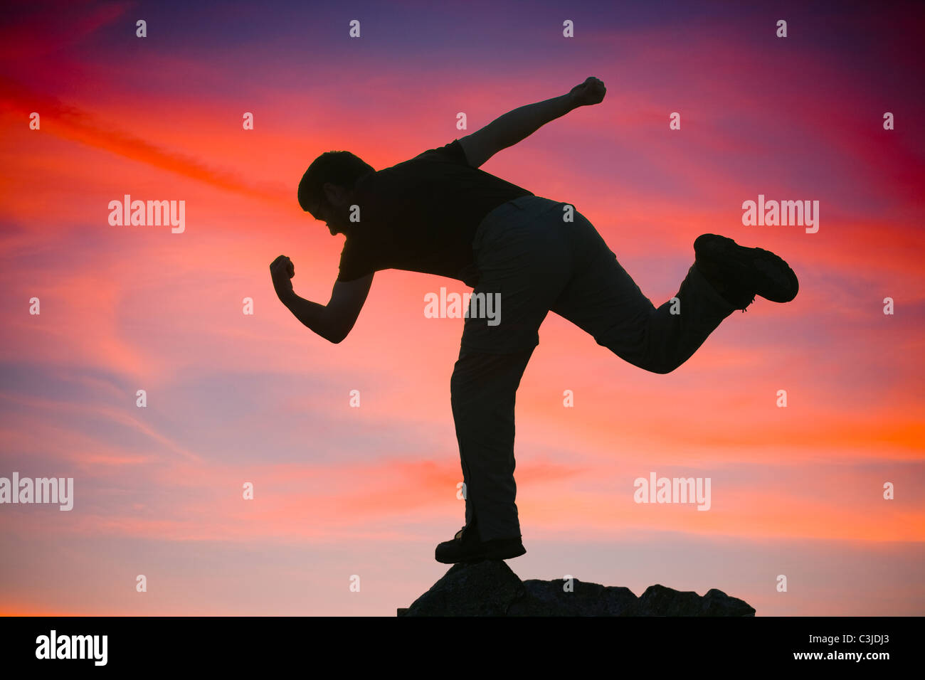 Clouds at sunset with a man balancing Stock Photo - Alamy