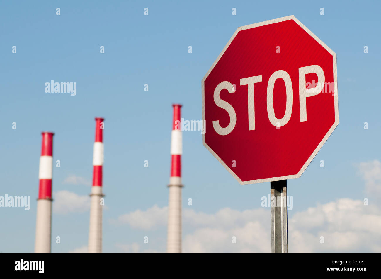 Stop sign with factory chimneys in background Stock Photo - Alamy