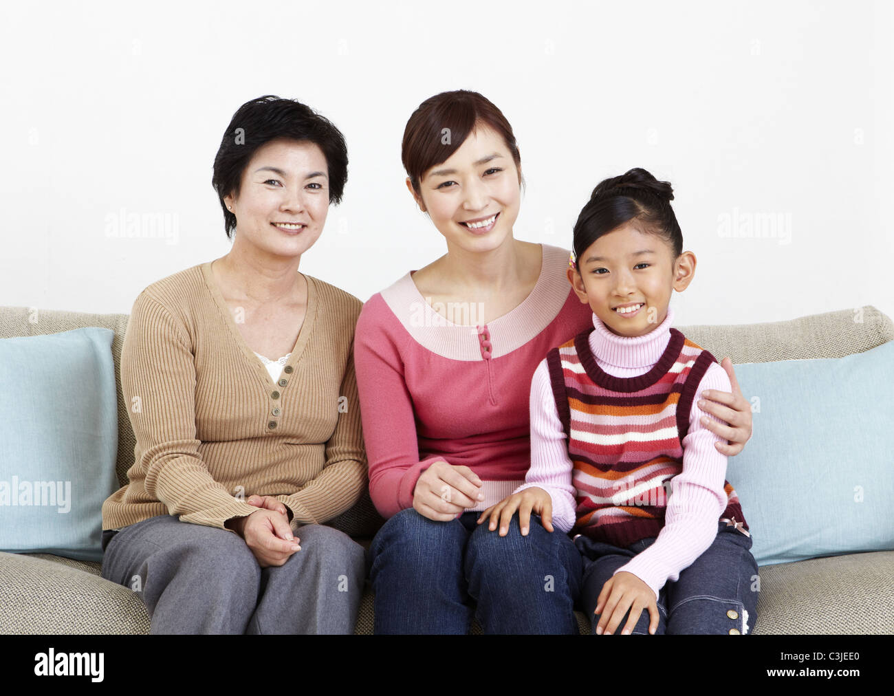 Three-generation family sitting on sofa Stock Photo - Alamy