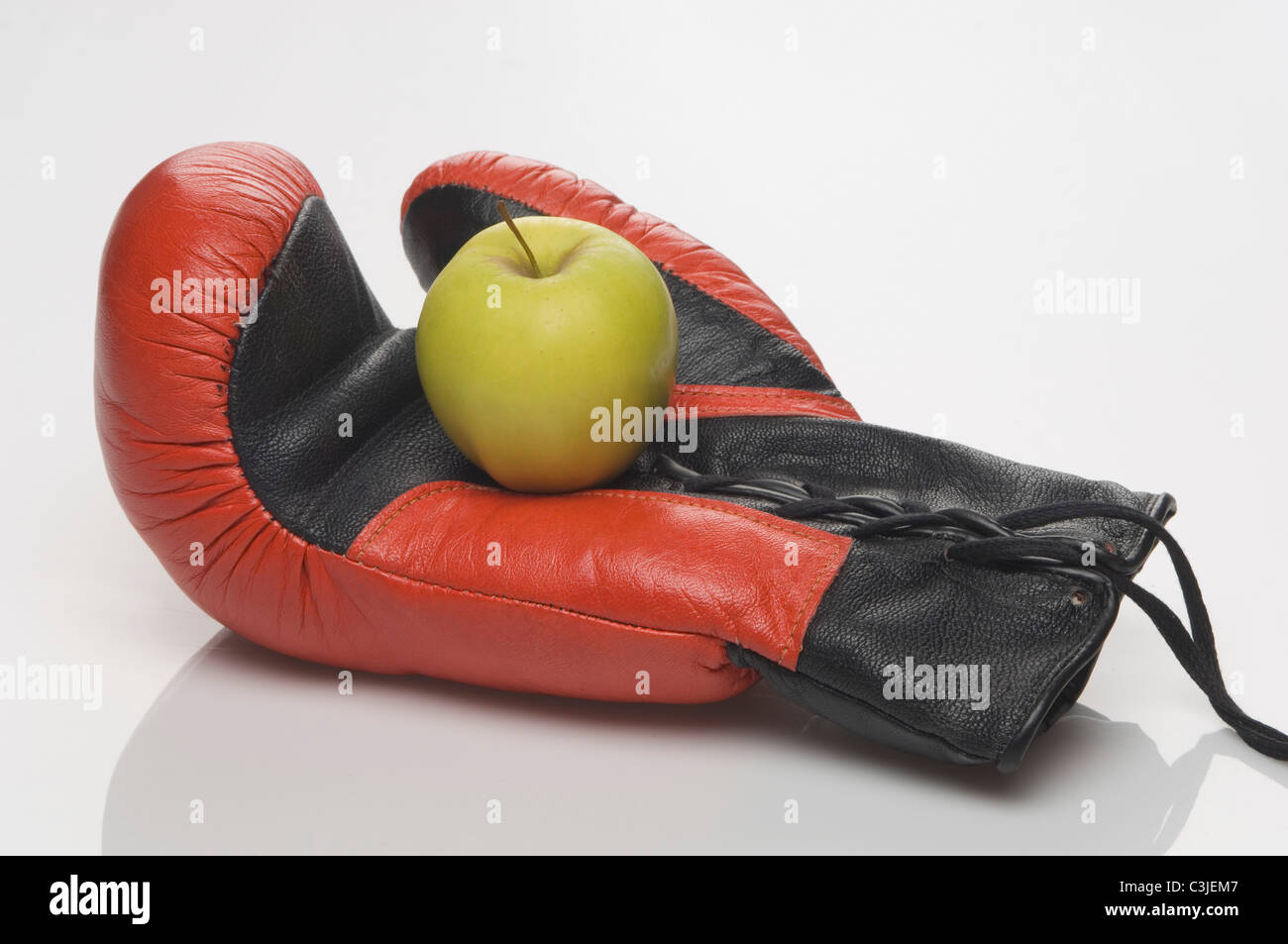Green apple on boxing glove, close up Stock Photo - Alamy