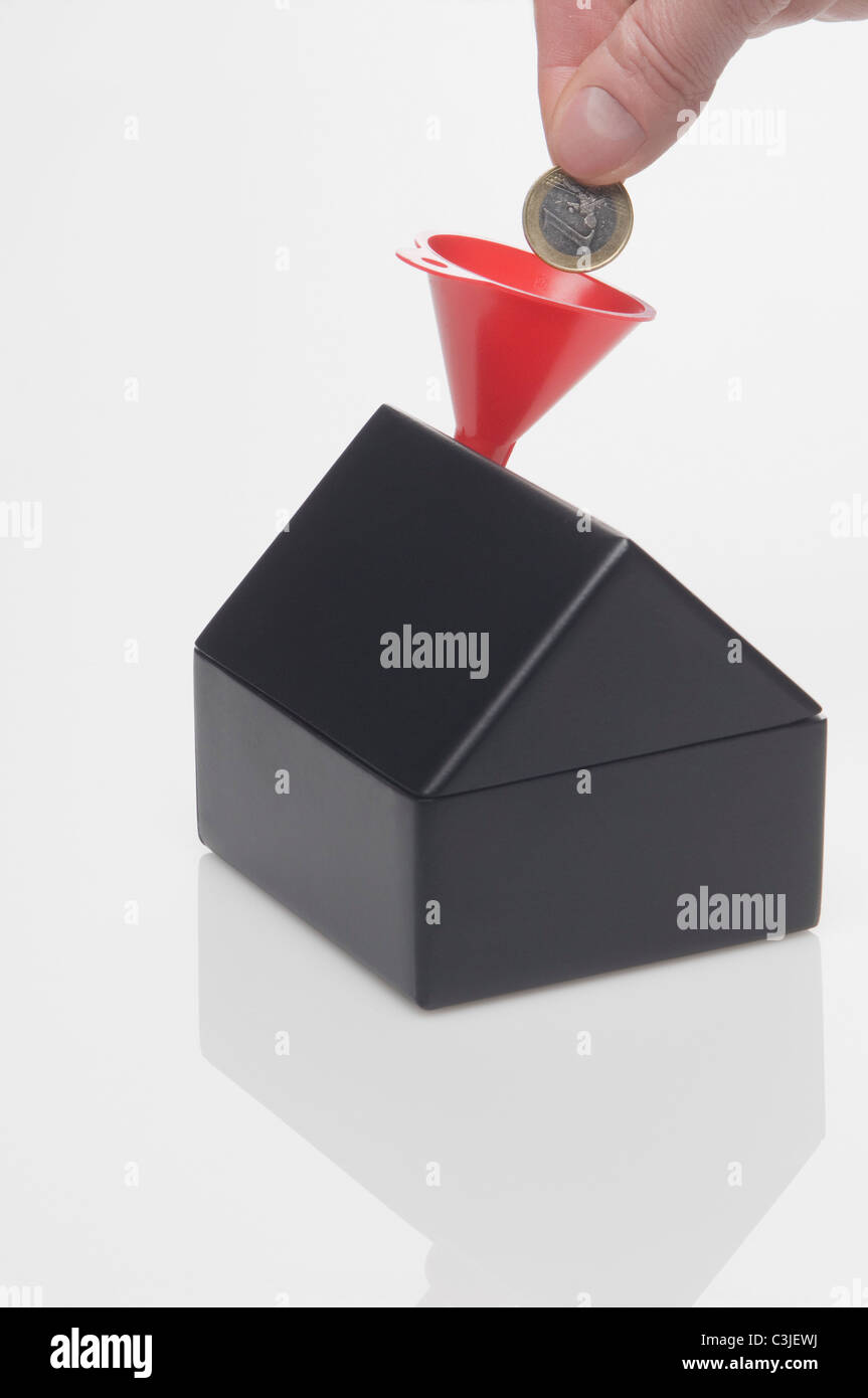 Human hand inserting euro coin in miniature house Stock Photo - Alamy