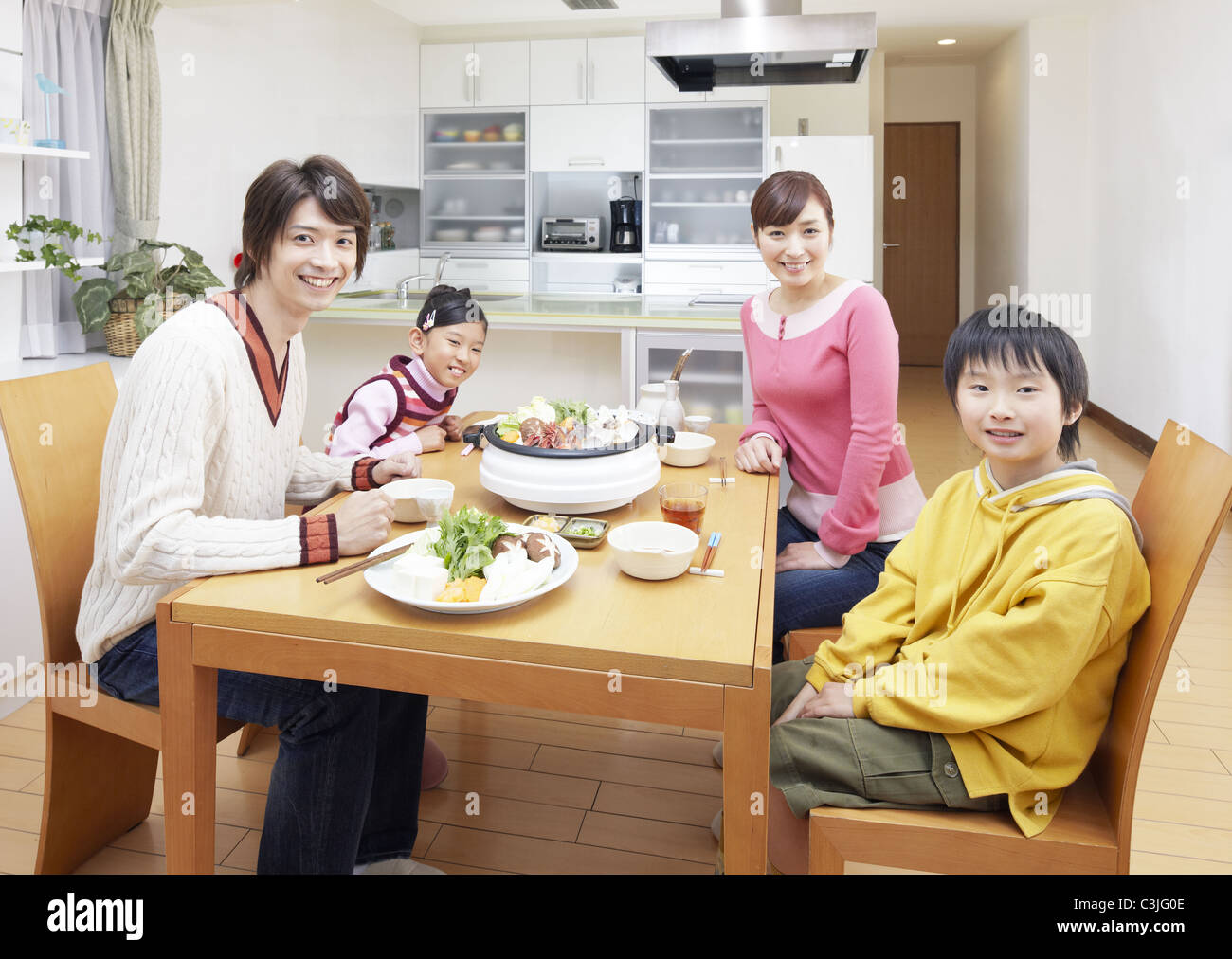 Parents and kids sitting around yosenabe Stock Photo - Alamy