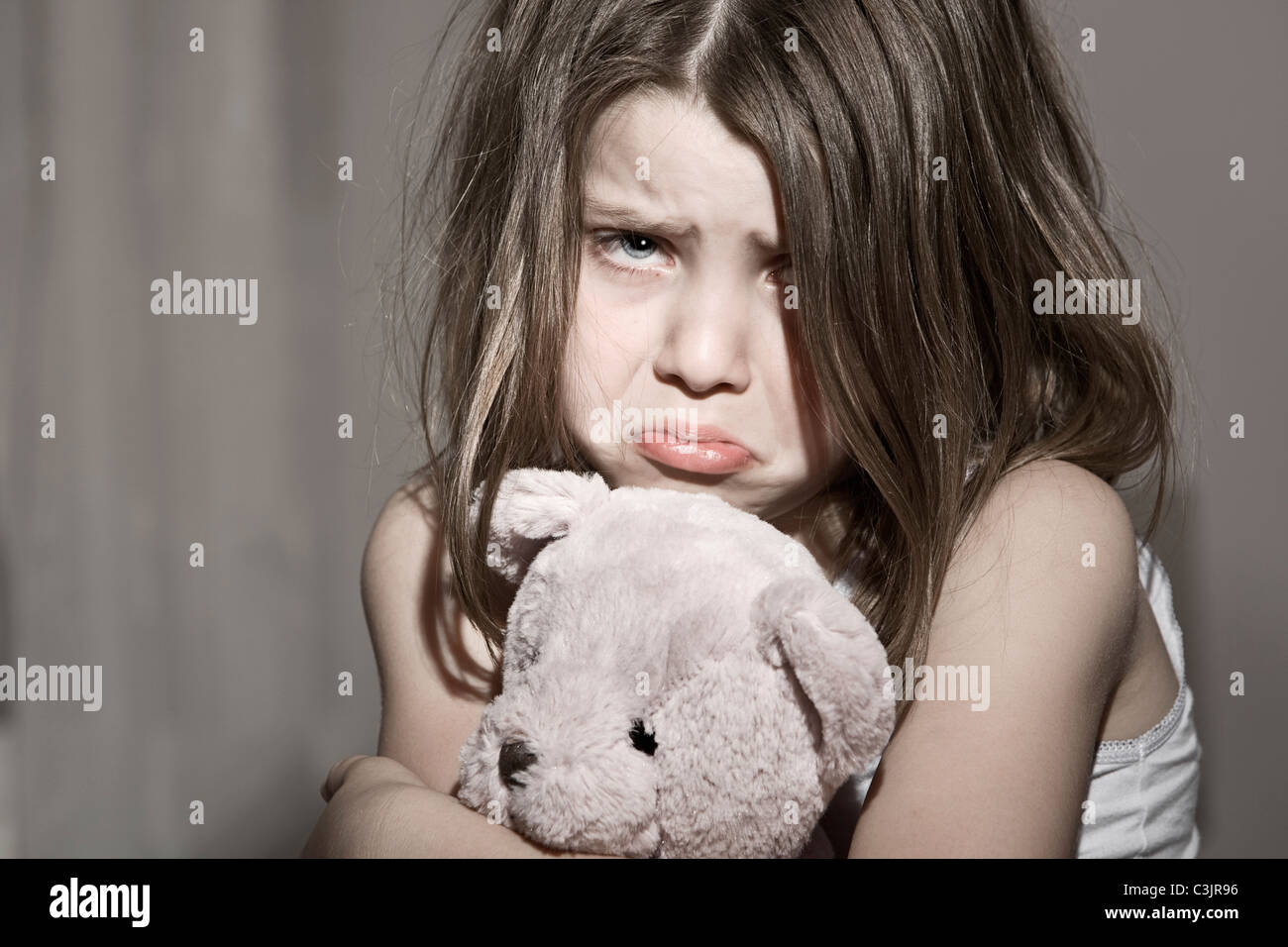 Studio portrait of sad girl (6-7) with pink teddy bear Stock Photo - Alamy