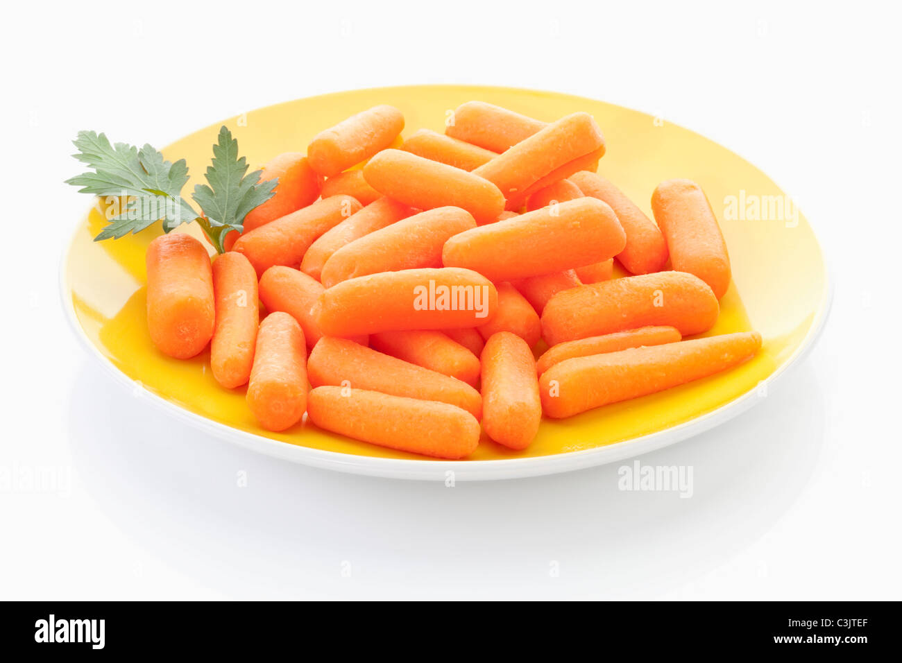 Baby carrot in plate on white background Stock Photo - Alamy