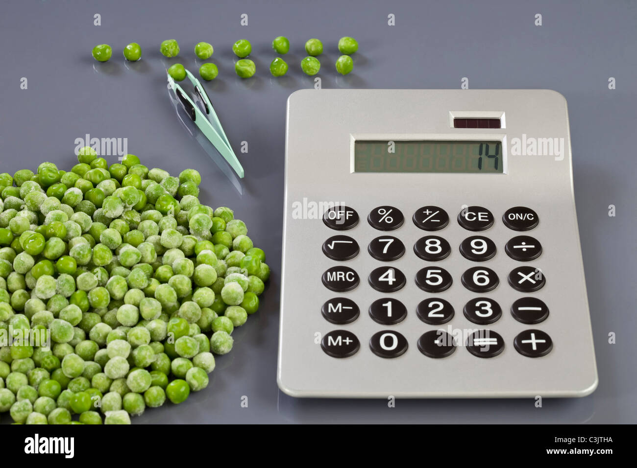 Green peas with tweezer and calculator on white background Stock Photo ...