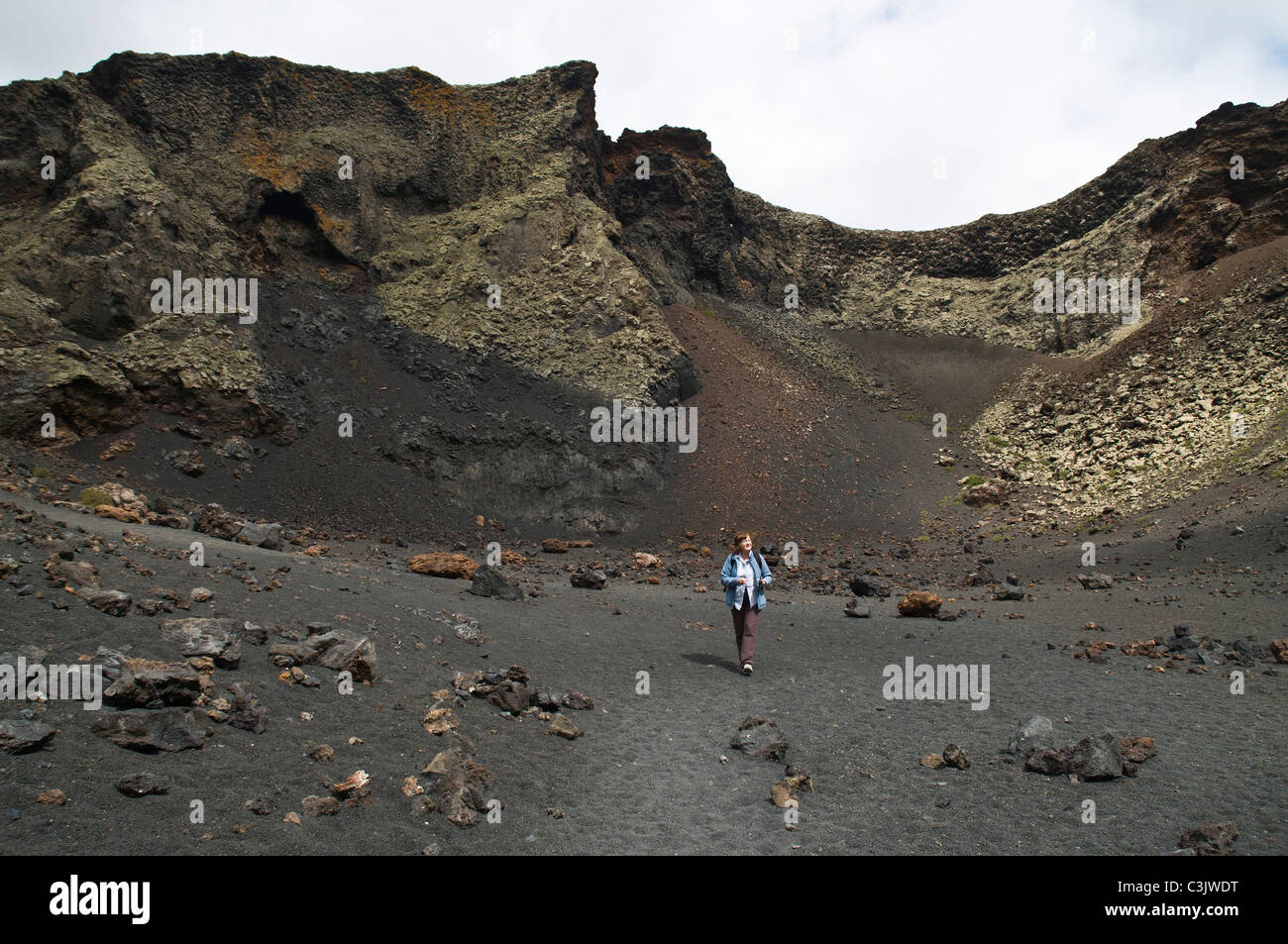 dh MONTANA CUERVO LANZAROTE Tourist woman walking inside volcano canary ...