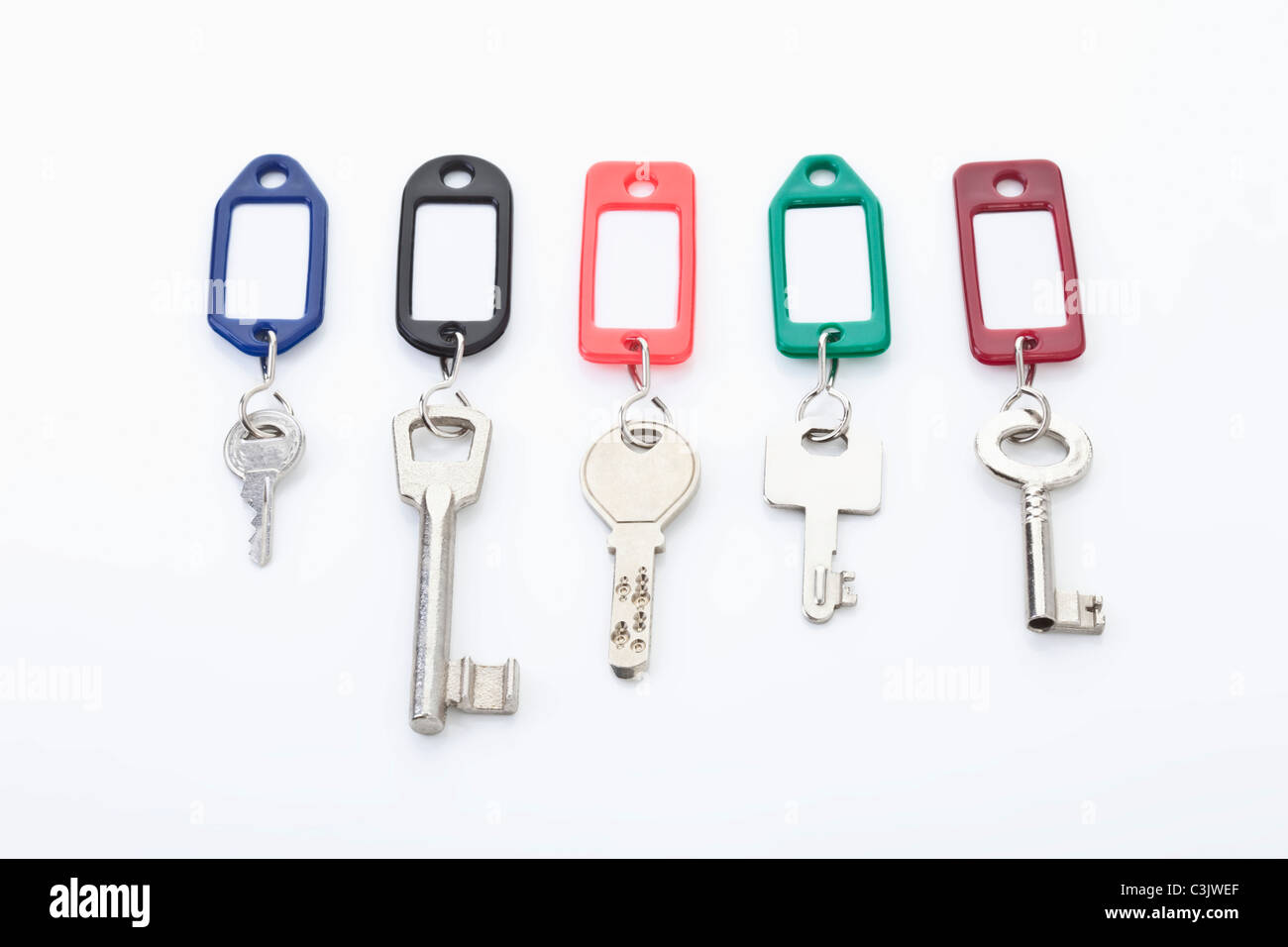 Keys with key rings on white background Stock Photo - Alamy