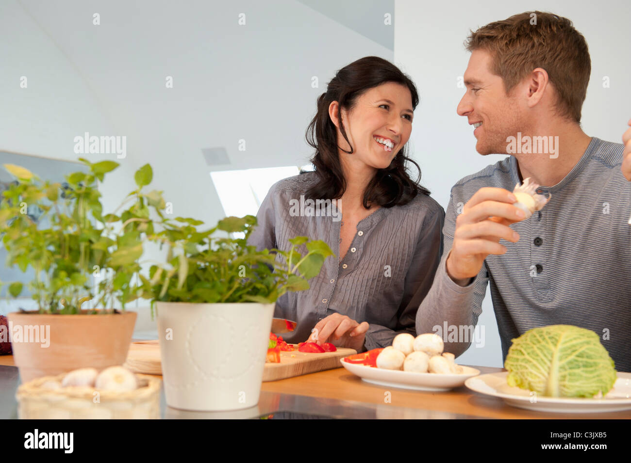 Germany, Munich, Man and woman cooking in kitchen, smiling Stock Photo ...