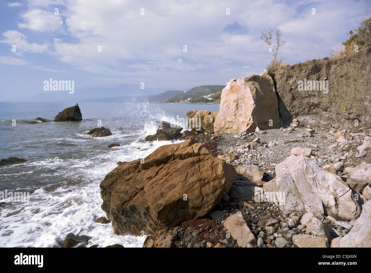 Coast of Black sea. Rocks, breaking waves and stones against a two ...
