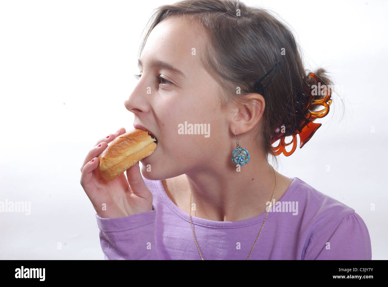 A young girl eating a bun Stock Photo - Alamy