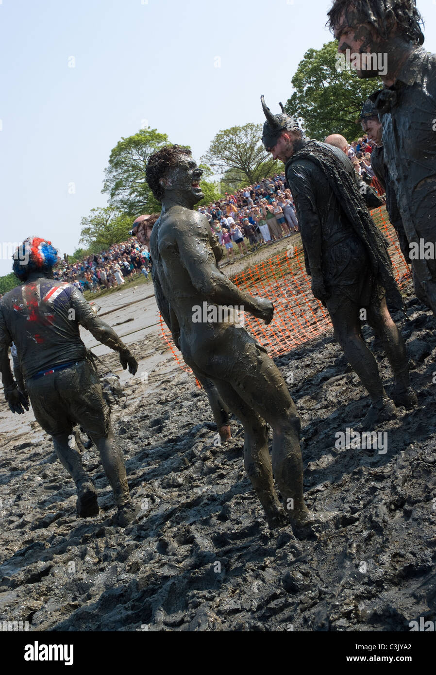 a fun runner stands naked at the finishing of the Maldon mud race after losing his in the Mud ...