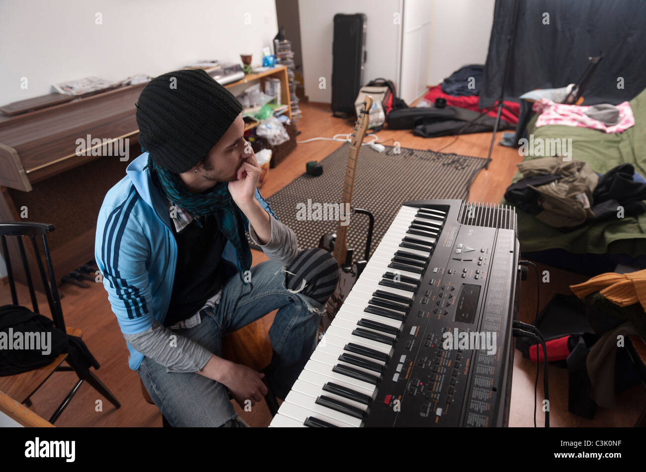 A young adult male playing keyboards in his home studio Stock Photo - Alamy