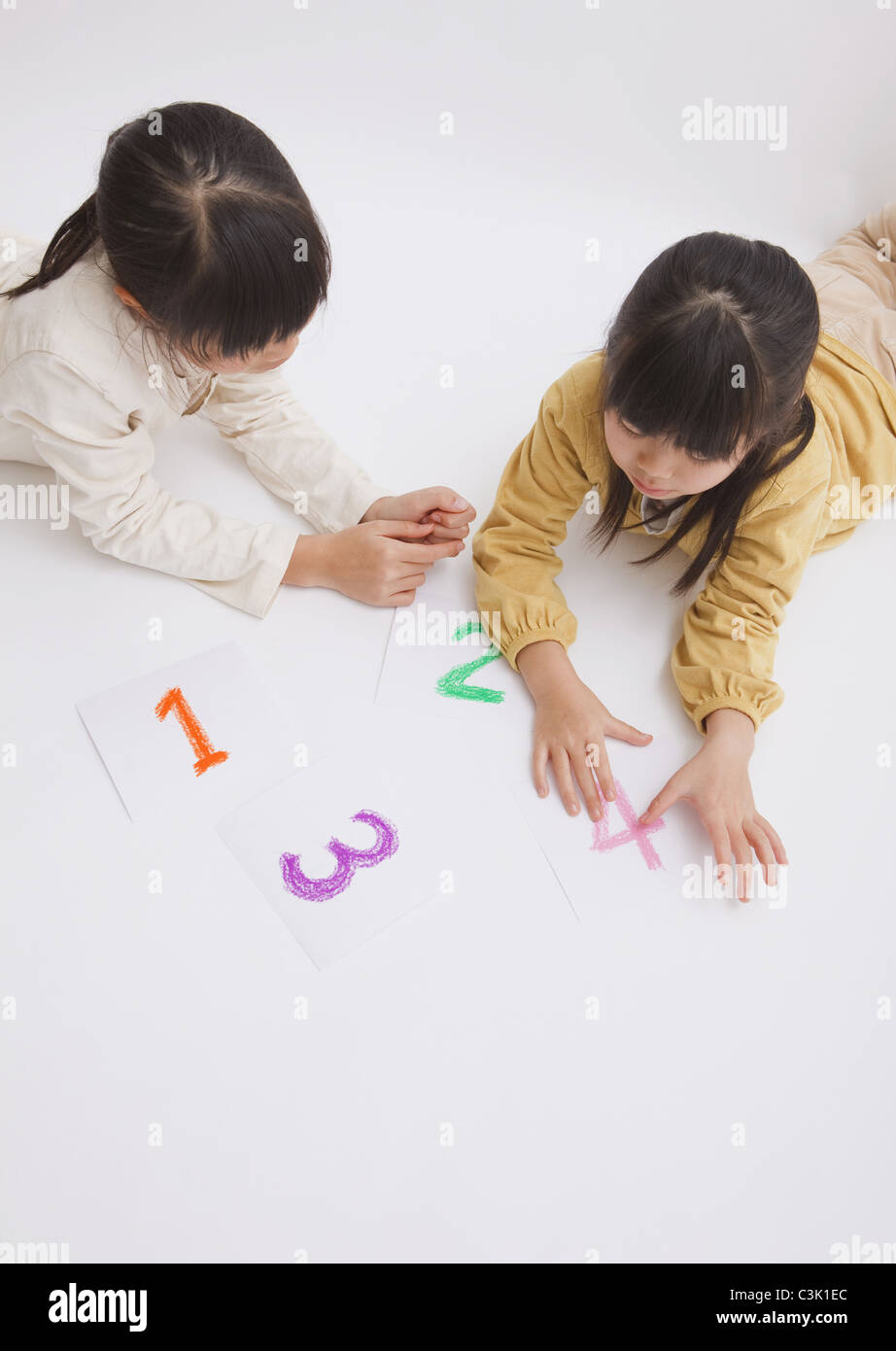 Sisters looking at number cards Stock Photo - Alamy