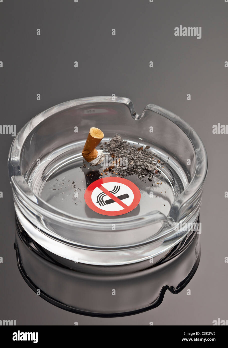 Cigarette in ashtray with no smoking sign Stock Photo - Alamy