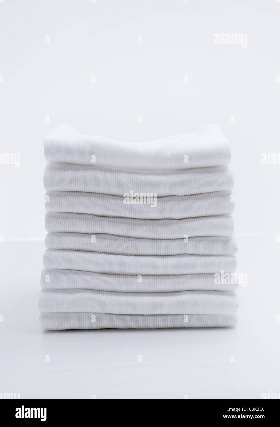 Stack of white shirts on white background Stock Photo - Alamy