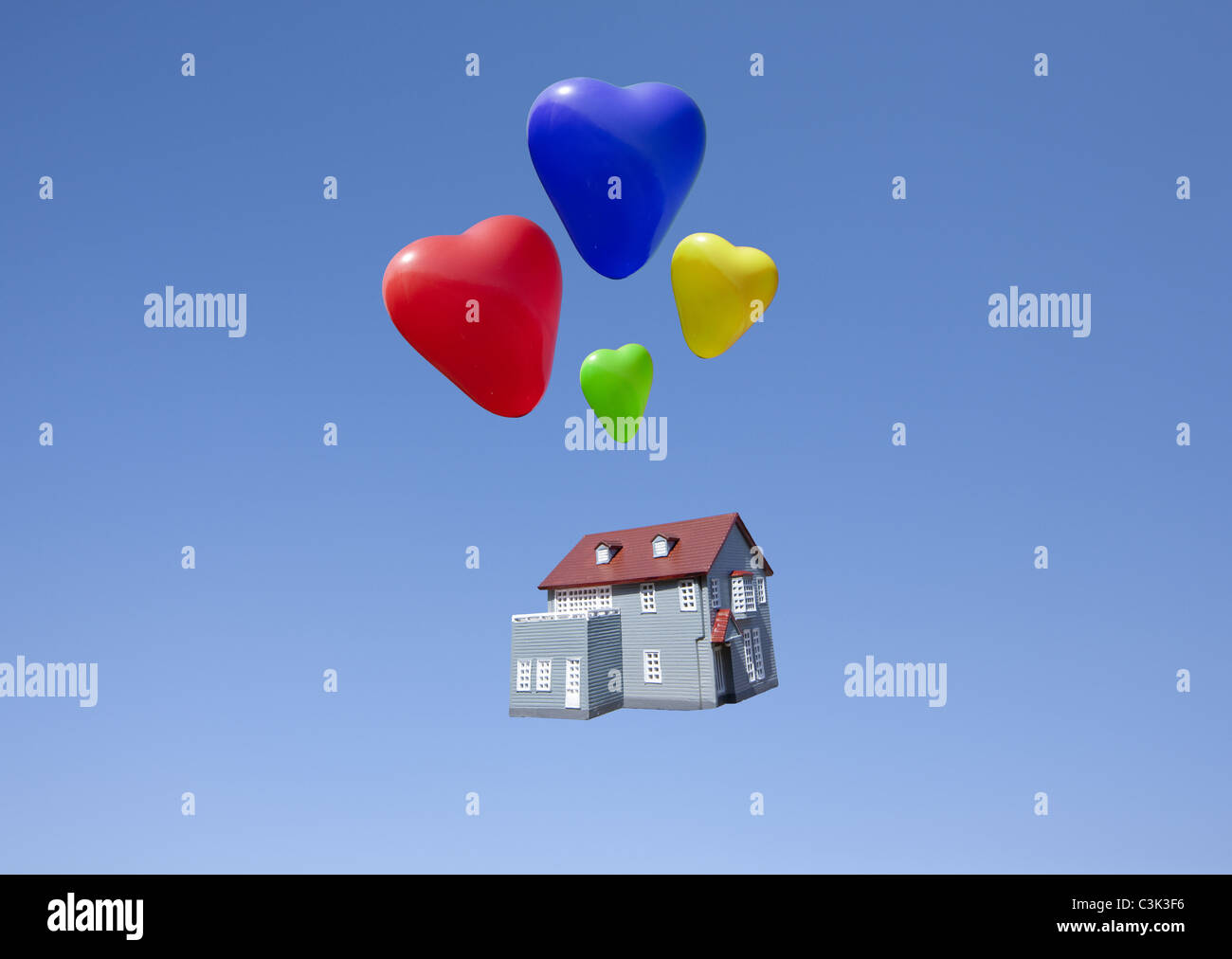 Heart shaped balloons and miniature house Stock Photo - Alamy