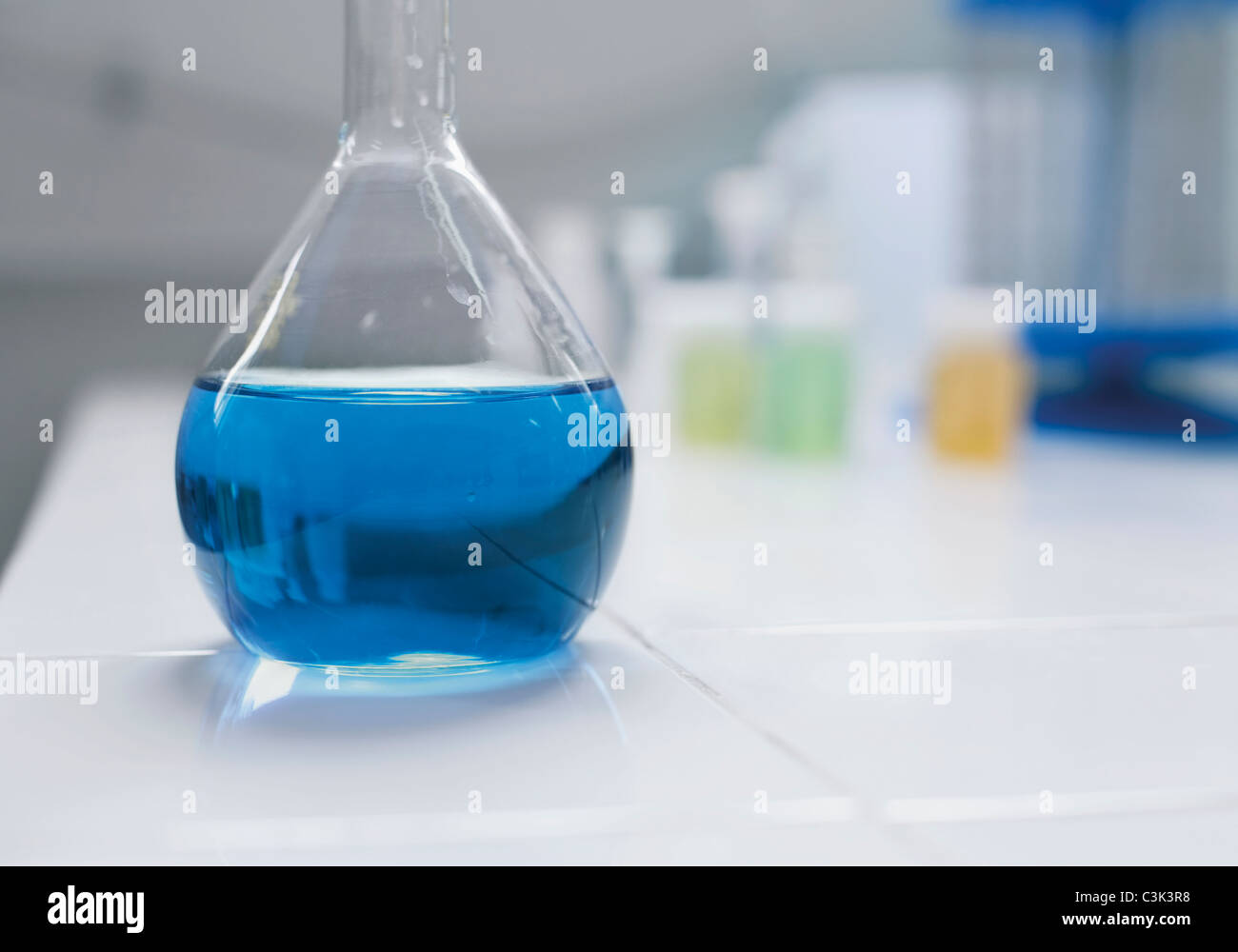 Glass flask with blue fluid, close up Stock Photo - Alamy