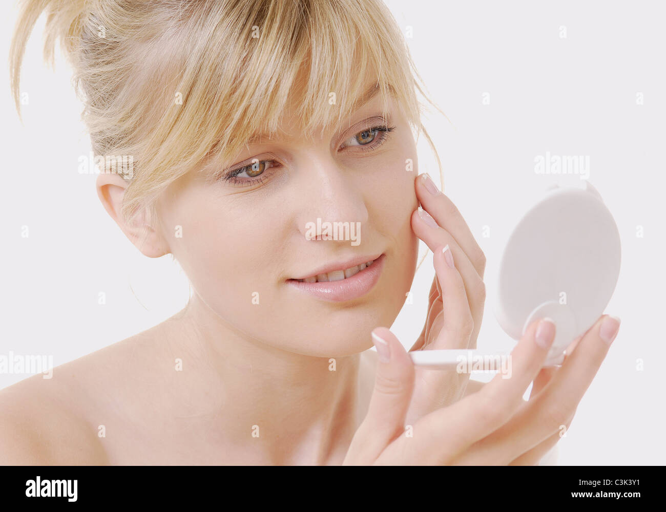 Young woman looking in hand mirror, close up Stock Photo - Alamy