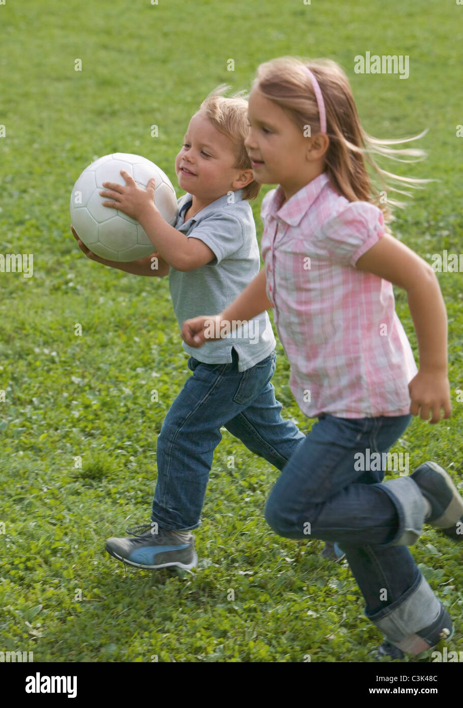 Children running with soccer ball Stock Photo - Alamy