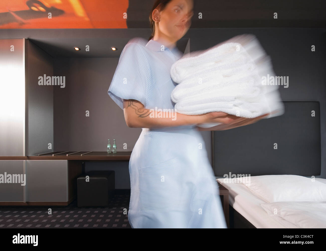 Germany, Maid with towels in a hotel room Stock Photo - Alamy