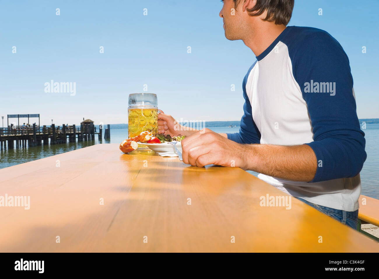 Germany, Ammersee, Young man eating outside Stock Photo - Alamy