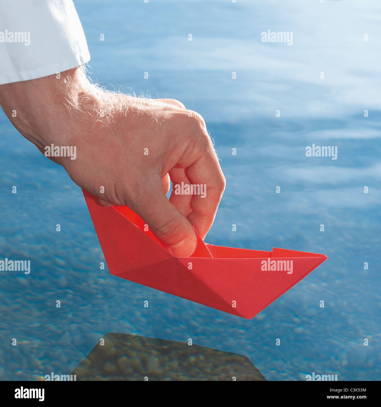 Human hand holding red origami boat hi-res stock photography and images ...