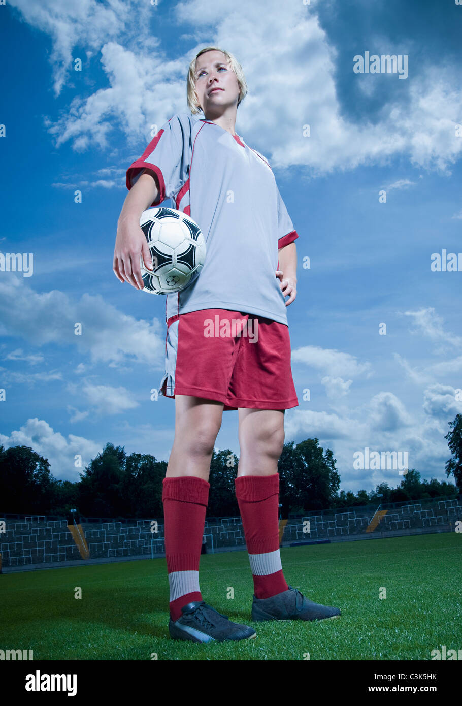 Germany, Augsburg, Soccer player holding ball underarm Stock Photo - Alamy