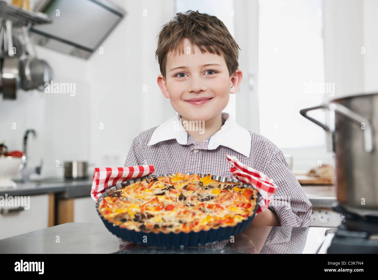 Germany, Cologne, Boy holding a pizza, smiling, portrait Stock Photo ...
